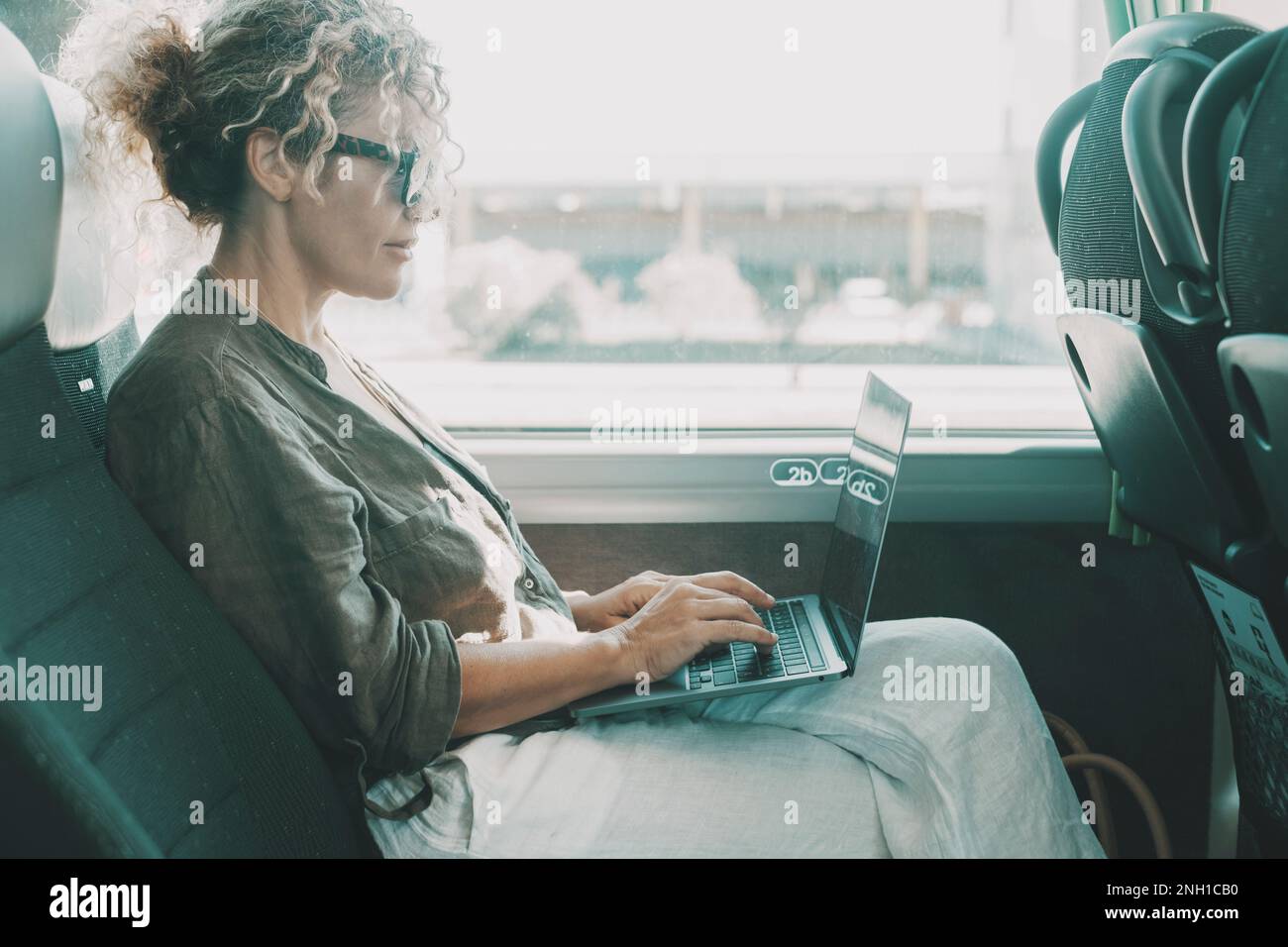One woman working on bus with laptop during passenger travel ...