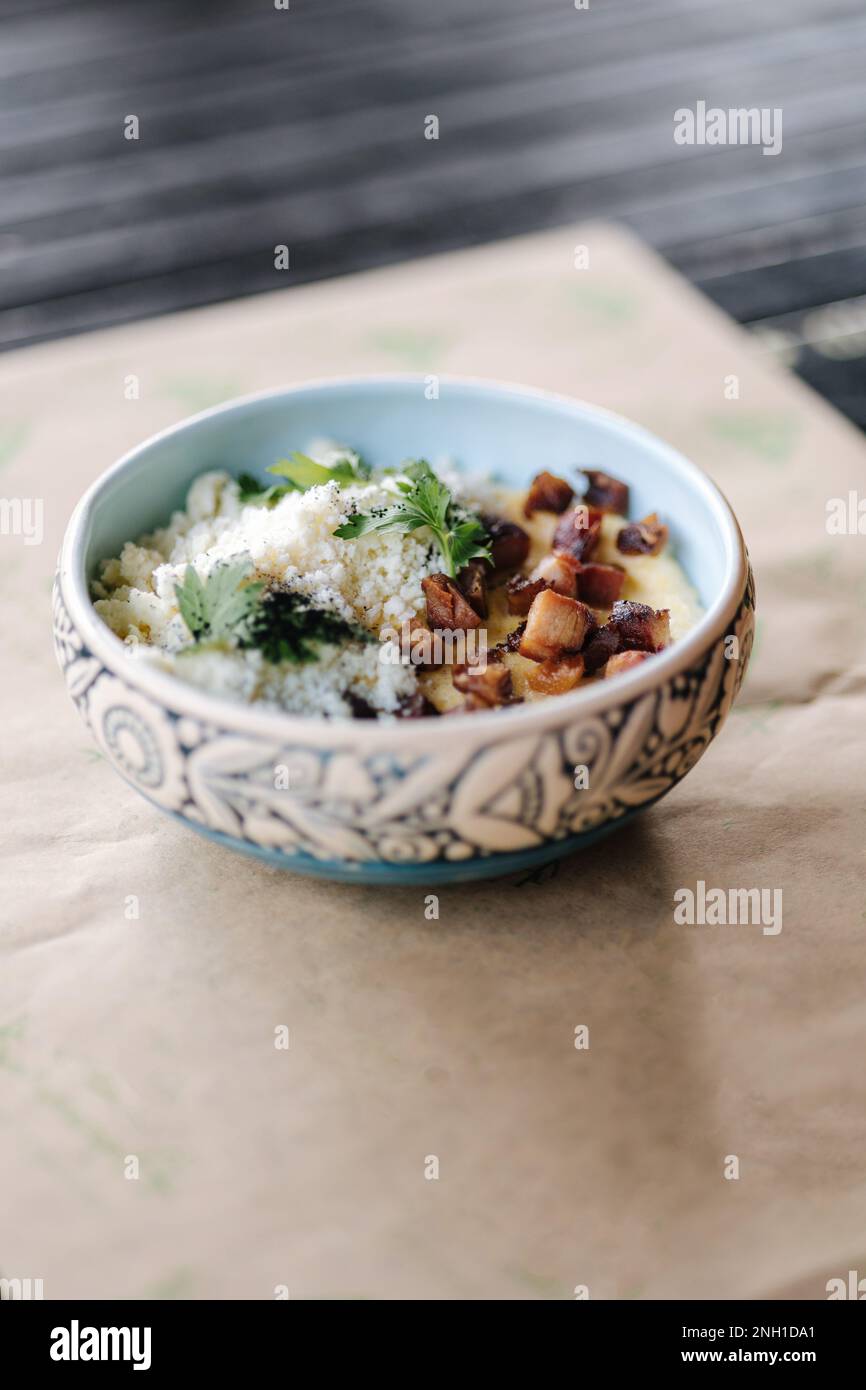 Traditional Ukrainian dish Banosh. Corn porridge in butter sprinkled on ...