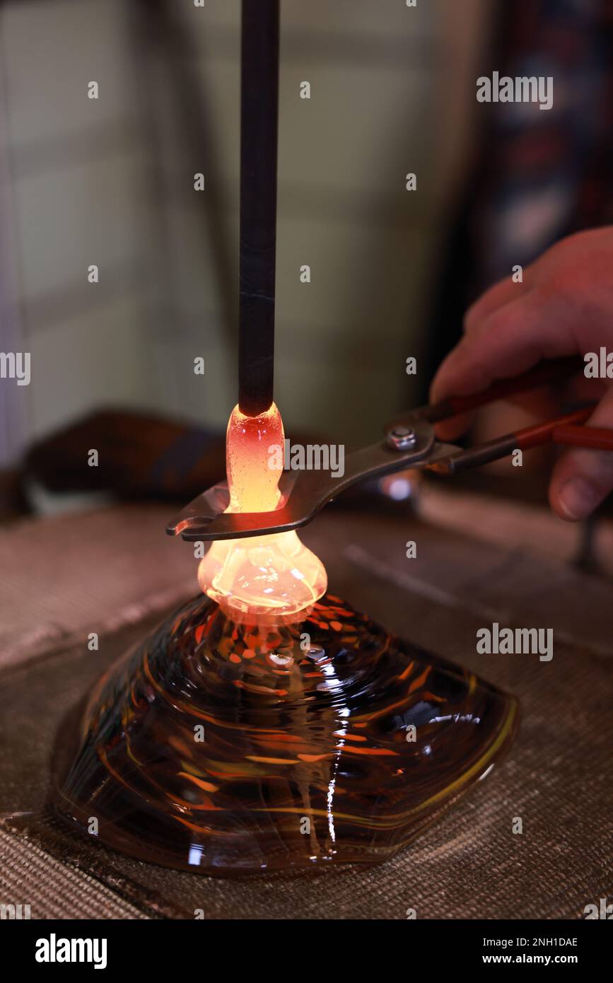 A glass blower forming beautiful piece of glass Stock Photo - Alamy