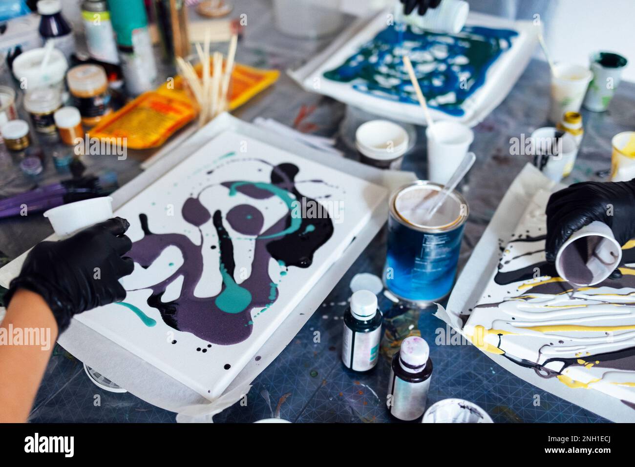 Master class on an Acrylic Fluid Pouring. Teacher and teen girl paint ...