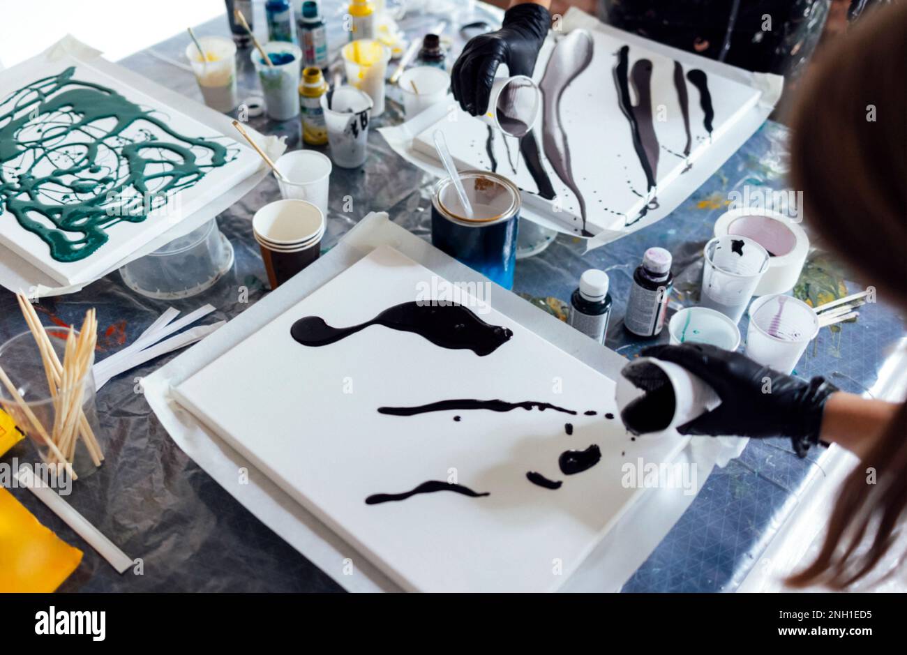 Master class on an Acrylic Fluid Pouring. Teacher and teen girl paint ...