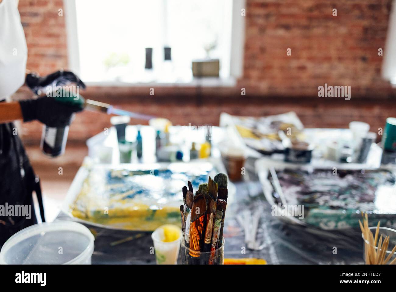 Woman uses a gas burner to draw in Fluid Art. Process of creating a ...