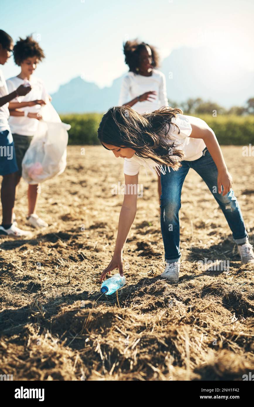 On pollution patrol. a group of teenagers picking up litter off a field ...