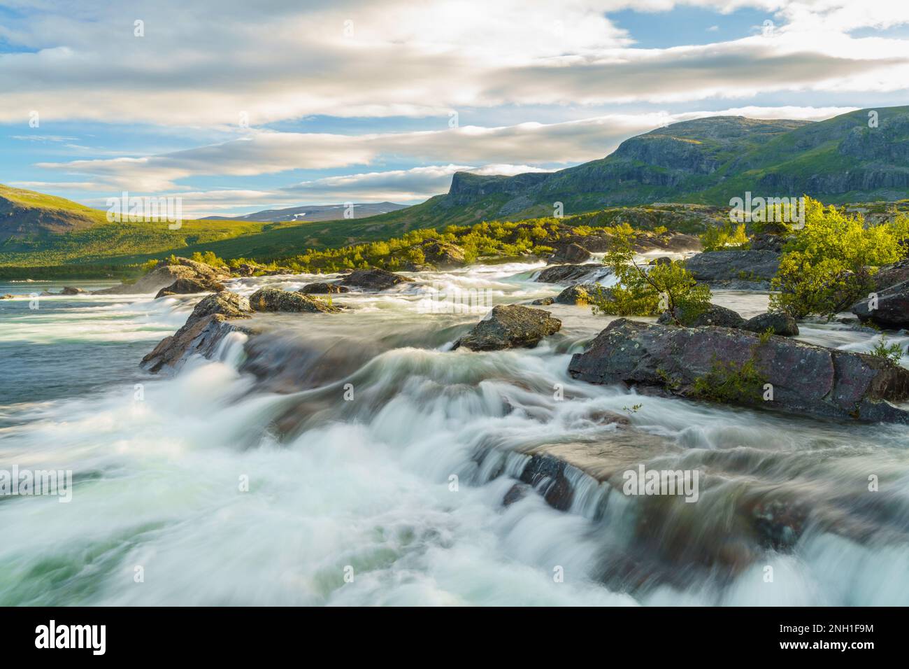 Waterfall in Stora sjöfallet national park with green birch trees and ...