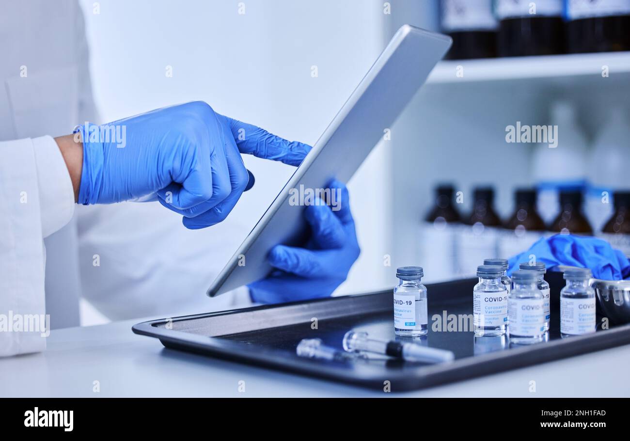 Logging every dose. an unrecognizable scientist working on a tablet in ...