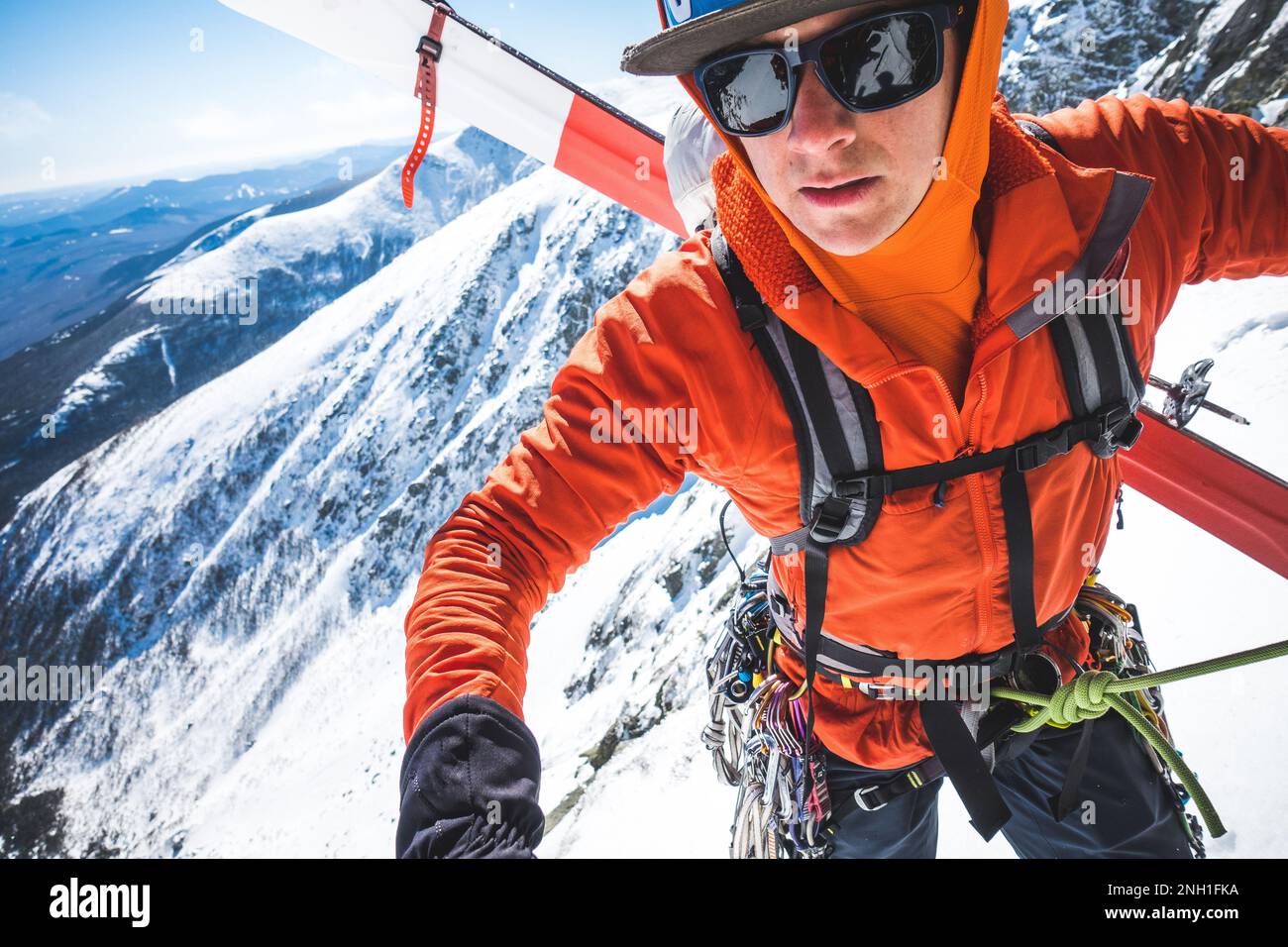 Ski-mountaineer organizing ropes with snowy mountains behind Stock ...