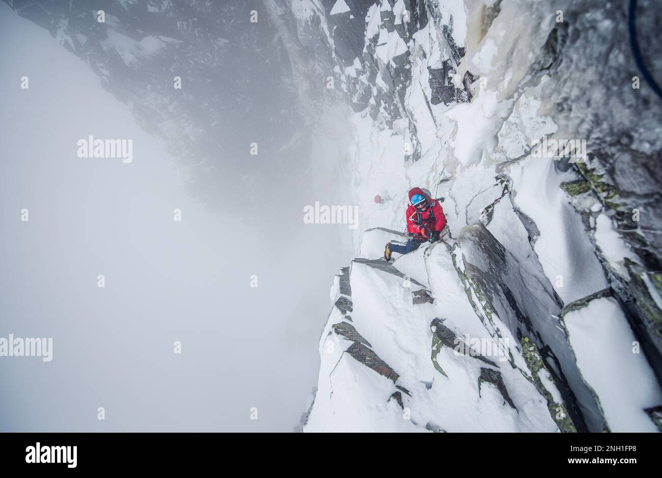 Ice climber mixed climbing a steep section of rock and ice Stock Photo ...
