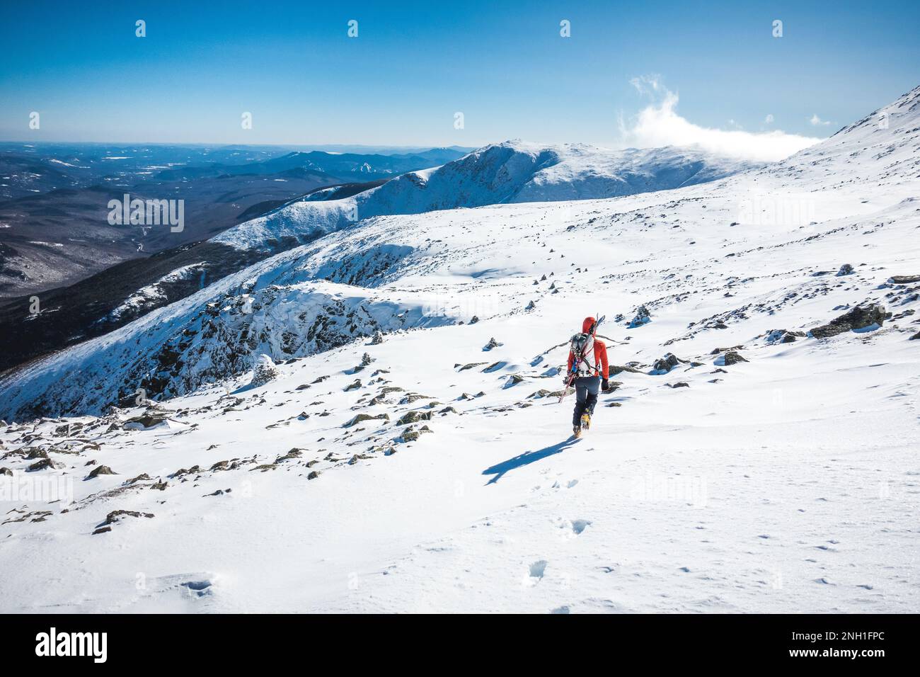 Ski mountaineer walking through frozen snow field on mountain Stock ...