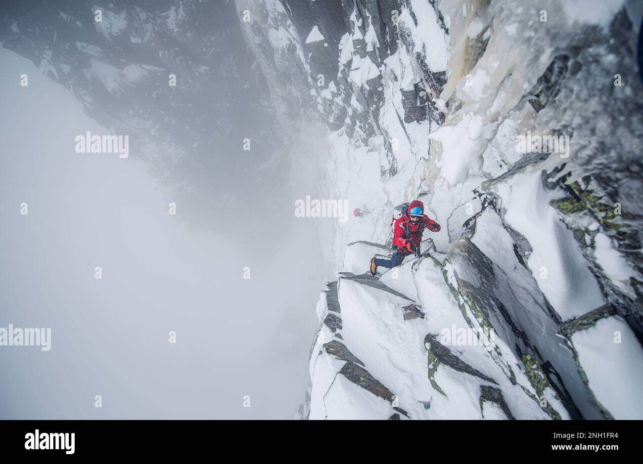 Ice climber mixed climbing a steep section of rock and ice Stock Photo ...