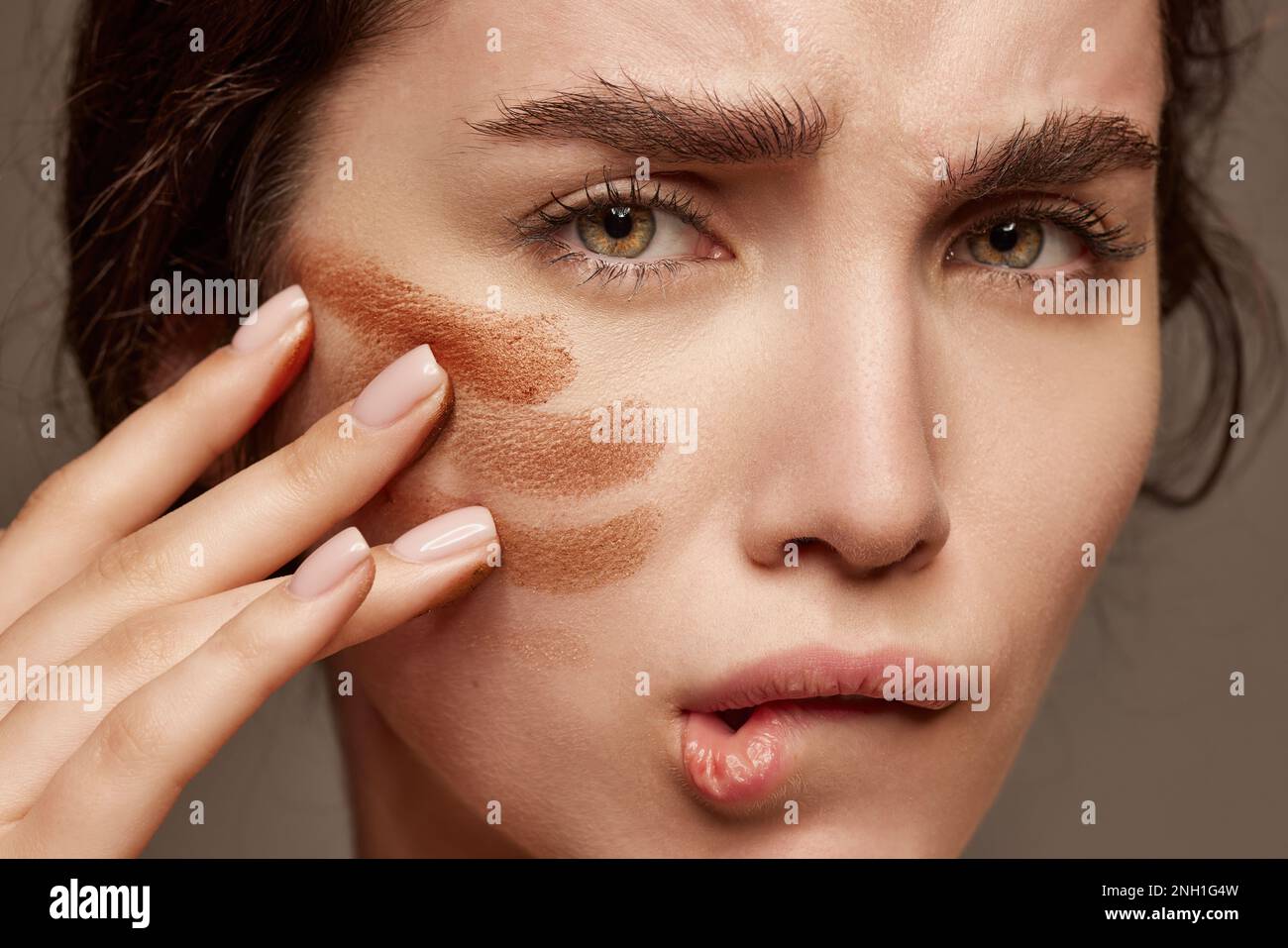 Portrait of young smiling beautiful girl with brown hair applying ...