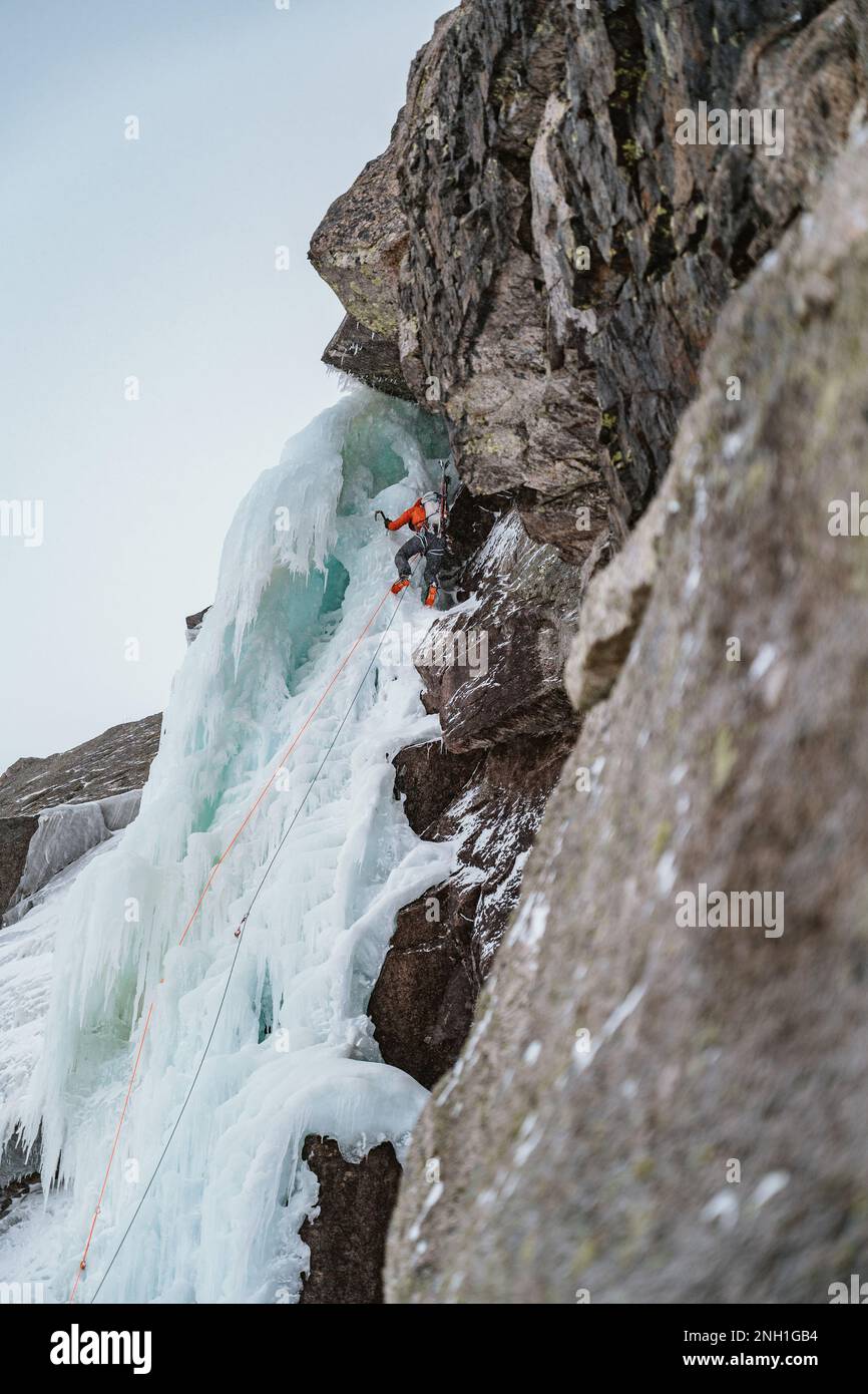 Man climbing steep ice and rock while ski-mountaineering Stock Photo ...