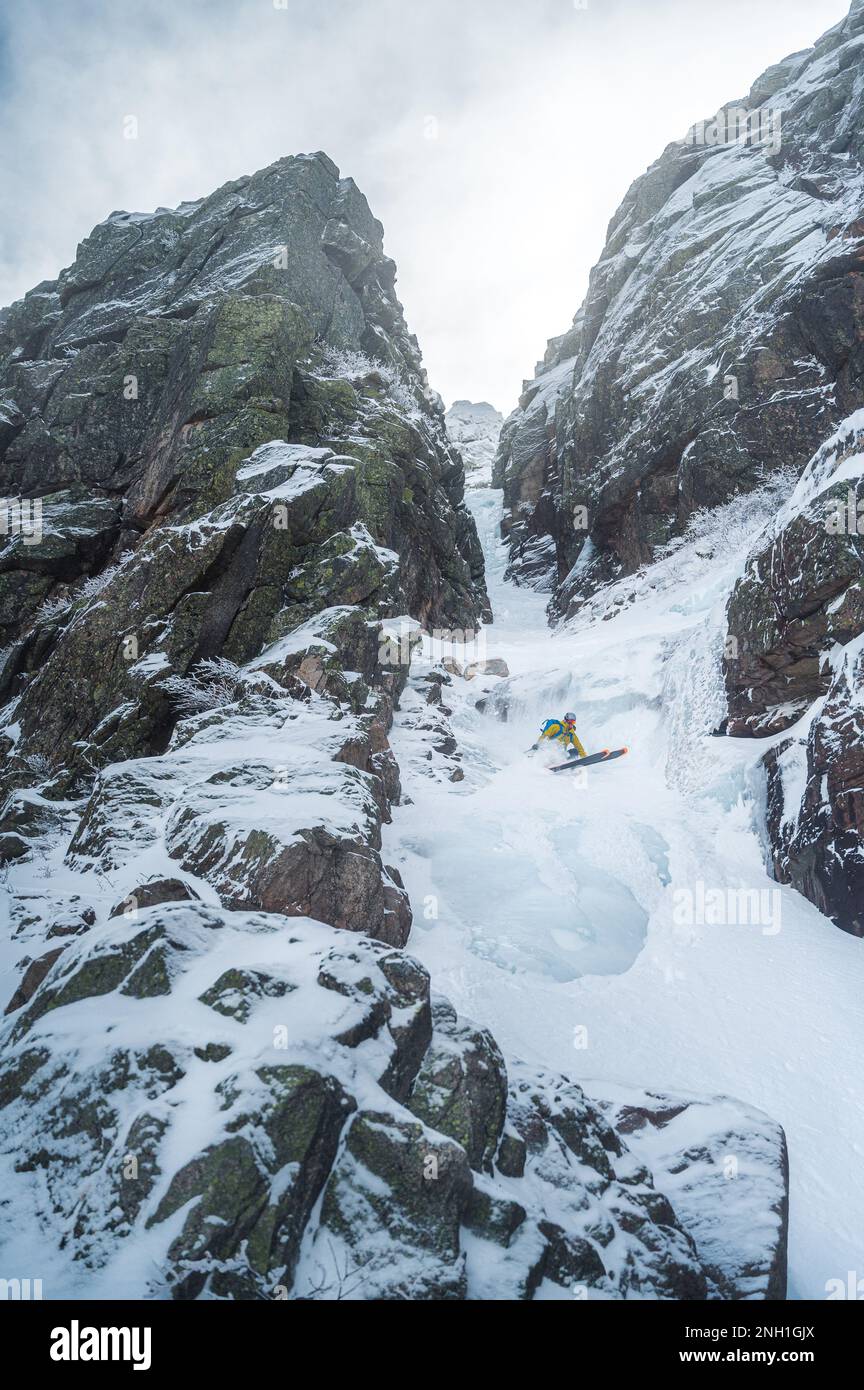Man skiing technical ice gully surrounded by rock walls Stock Photo - Alamy