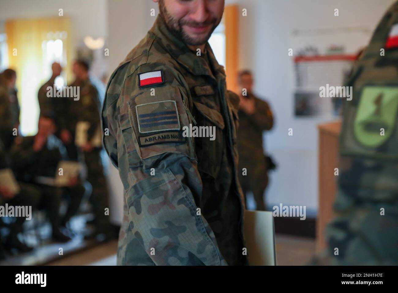 A Polish soldier is awarded an Abrams number 1 patch signifying ...