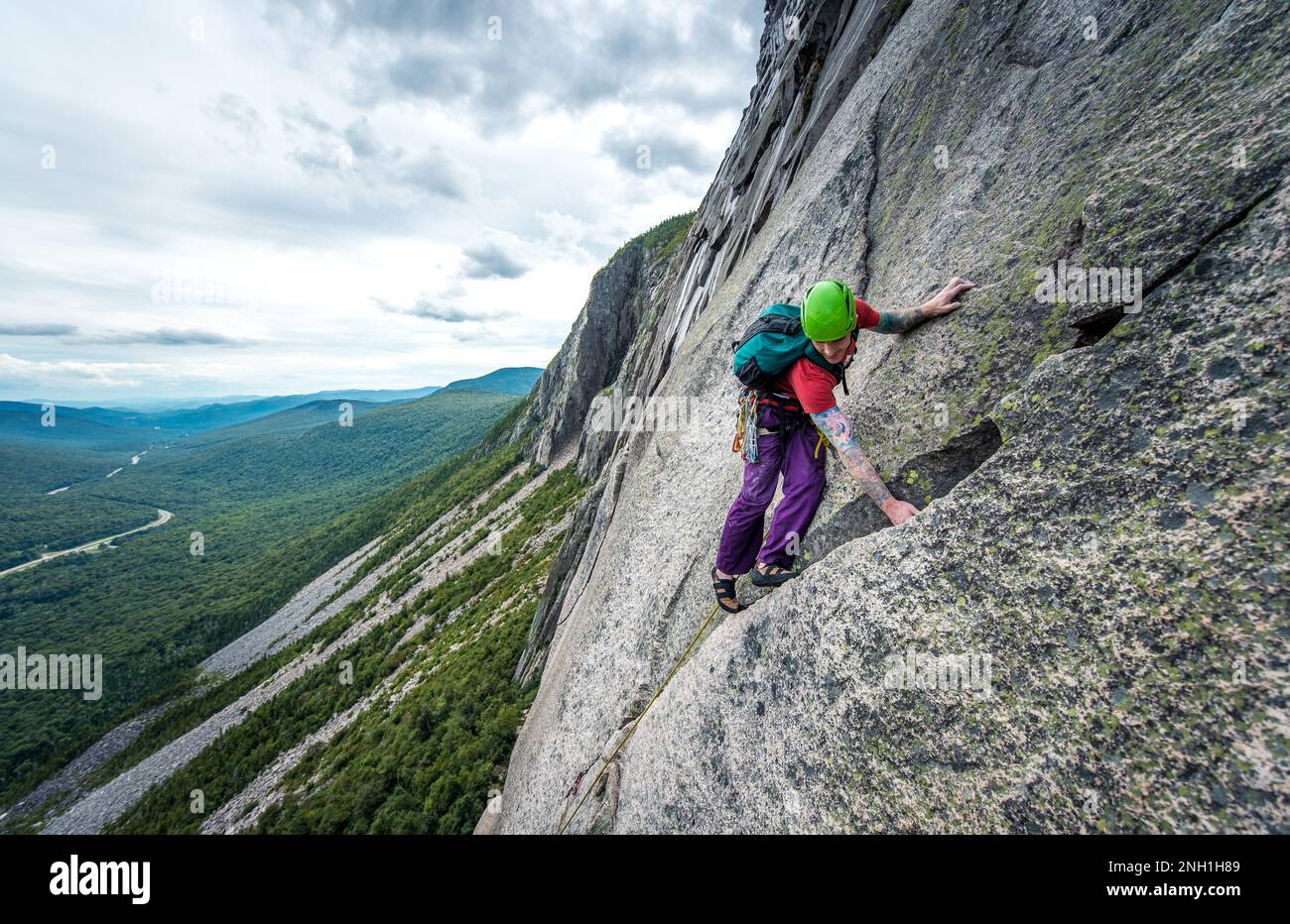 Man rock climbing steep crack on cliff with valley behind Stock Photo ...