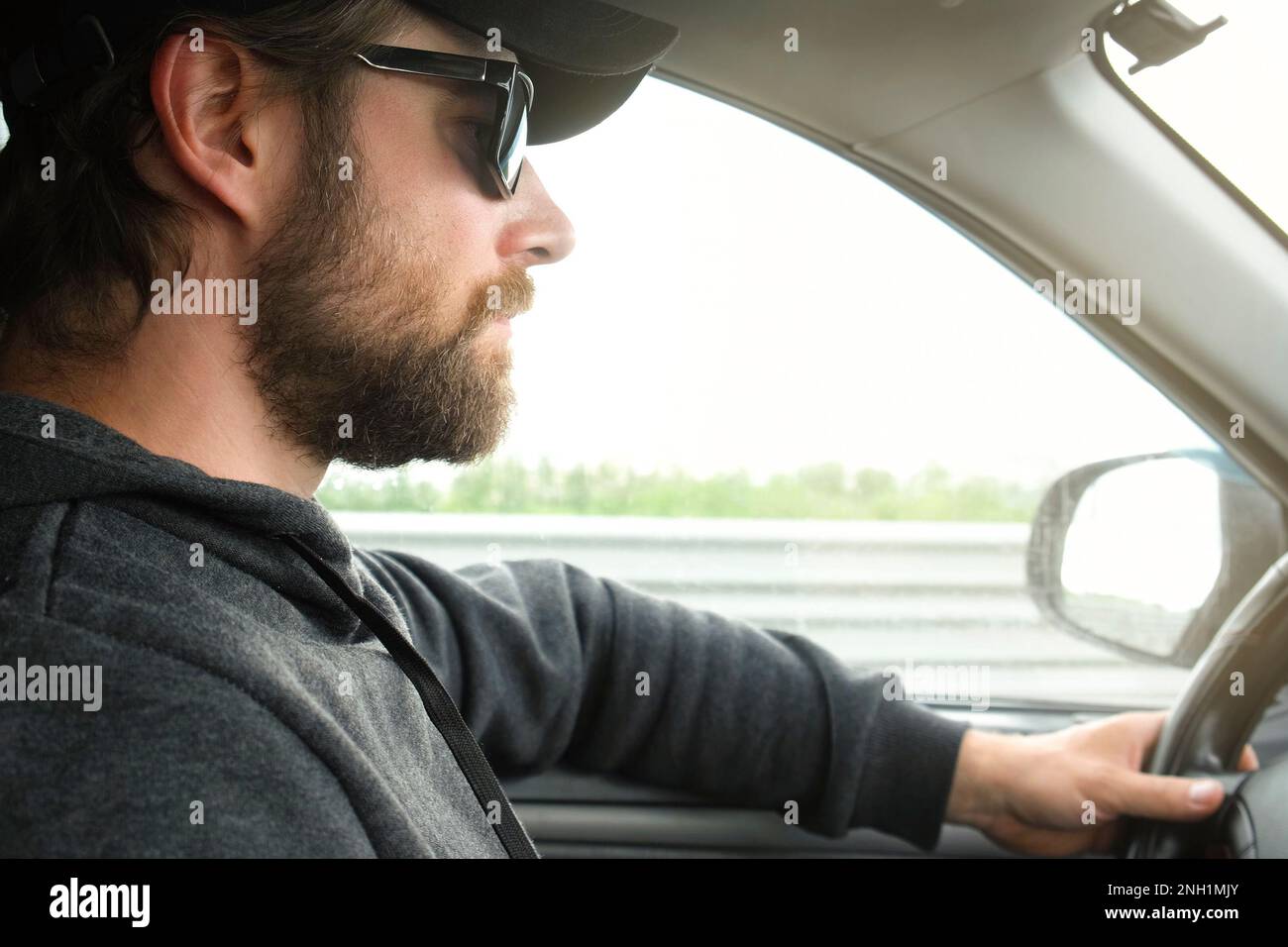 Man Driving a Car at Sunset. Male Hand on steering wheel close up ...