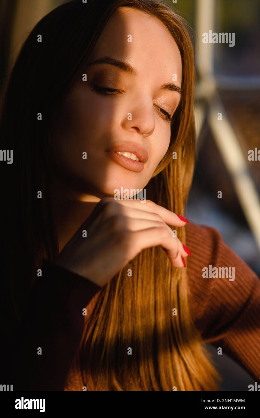 Portrait of a beautiful young girl with closed eyes illuminated by ...