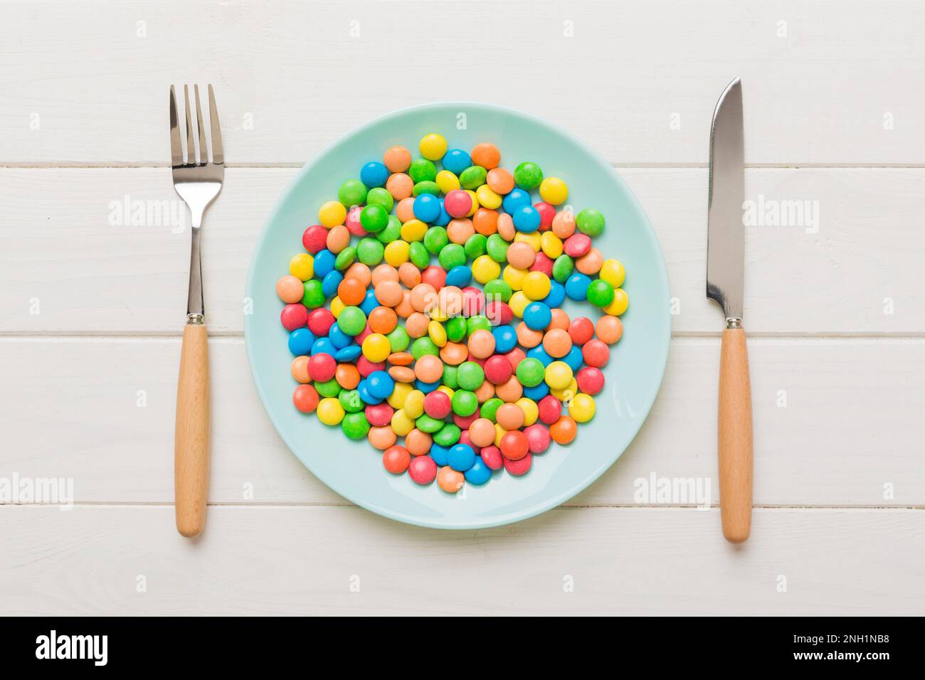 cutlery on table and sweet plate of candy. Health and obesity concept ...