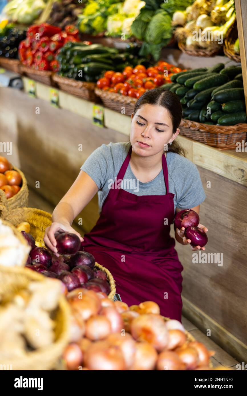 Young woman selling onions in shop Stock Photo - Alamy