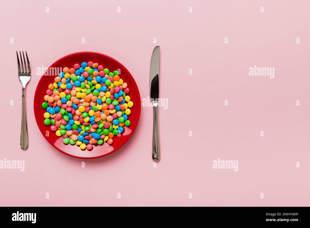 cutlery on table and sweet plate of candy. Health and obesity concept ...