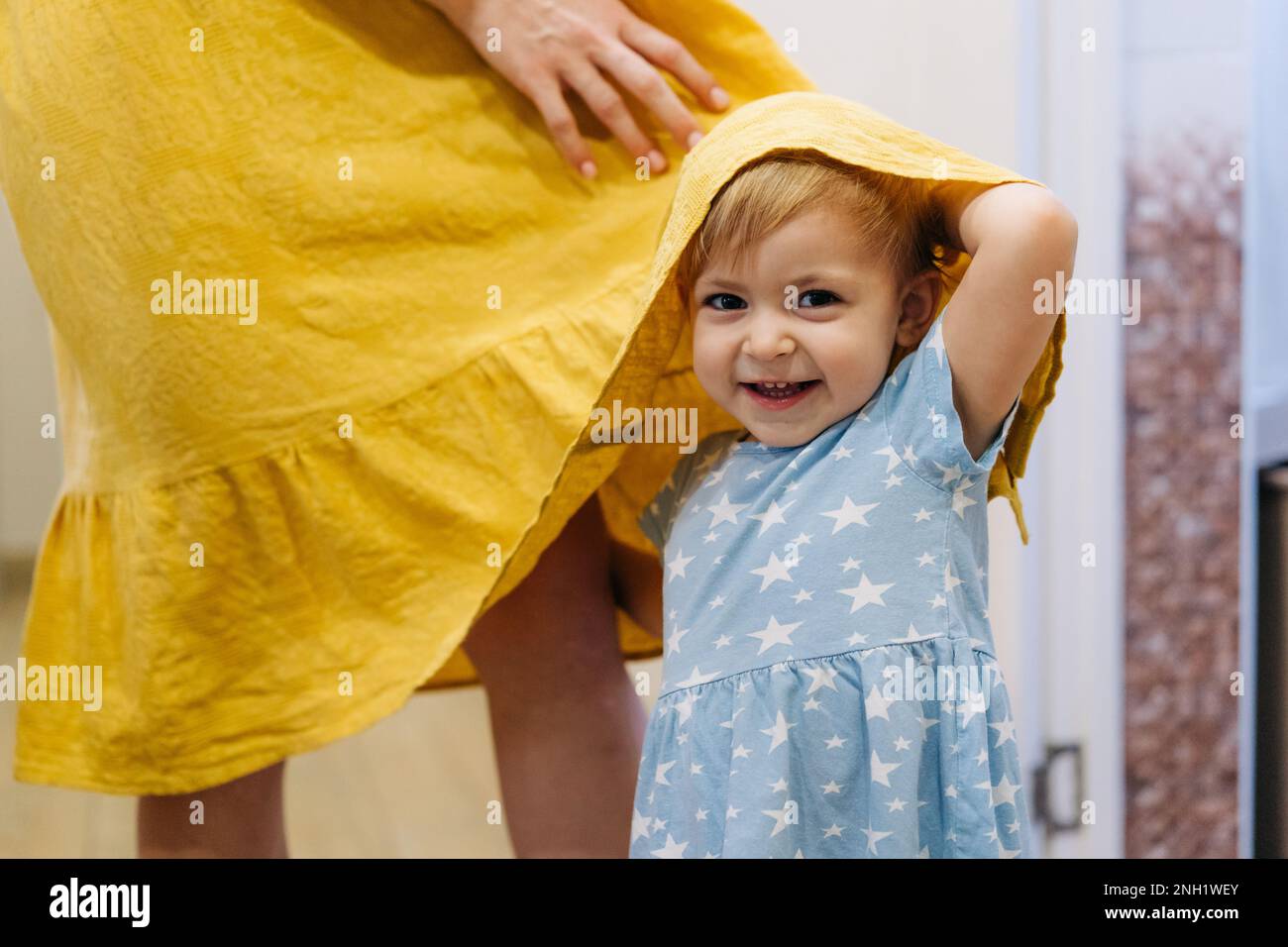 Little Playful Daughter Plays Hide And Seek Behind Her Mothers Skirt 7233