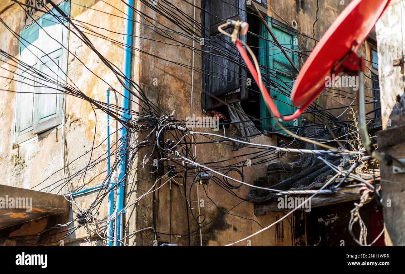 Intertwined electric wires in front of buildings which is the first ...