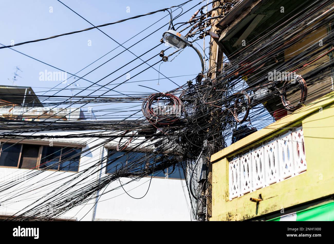 Intertwined electric wires in front of buildings which is the first ...