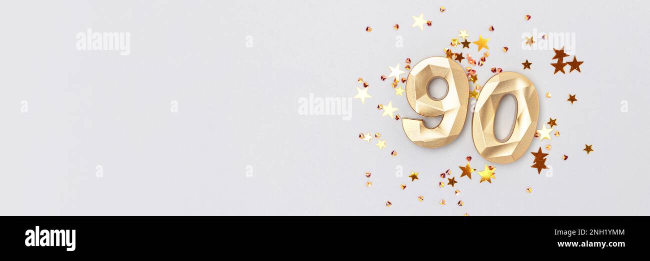 Banner with golden number 90 and shimmer stars confetti on a blue ...