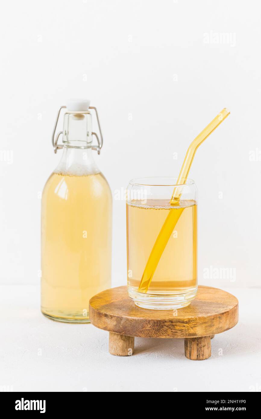 Homemade kombucha fermented drink in glass and bottle on white ...