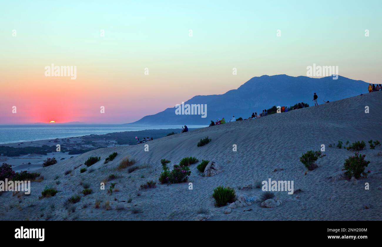Tourists watch the sunset on Patara beach near the ancient Lycian city ...