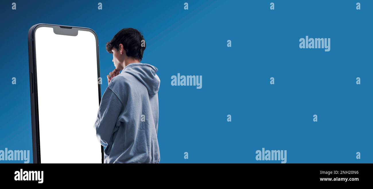 Pensive teenager staring at a big blank smartphone screen, teenagers ...