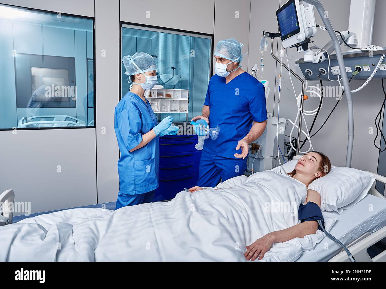 Female unconscious patient attached to medical monitoring equipment in ...