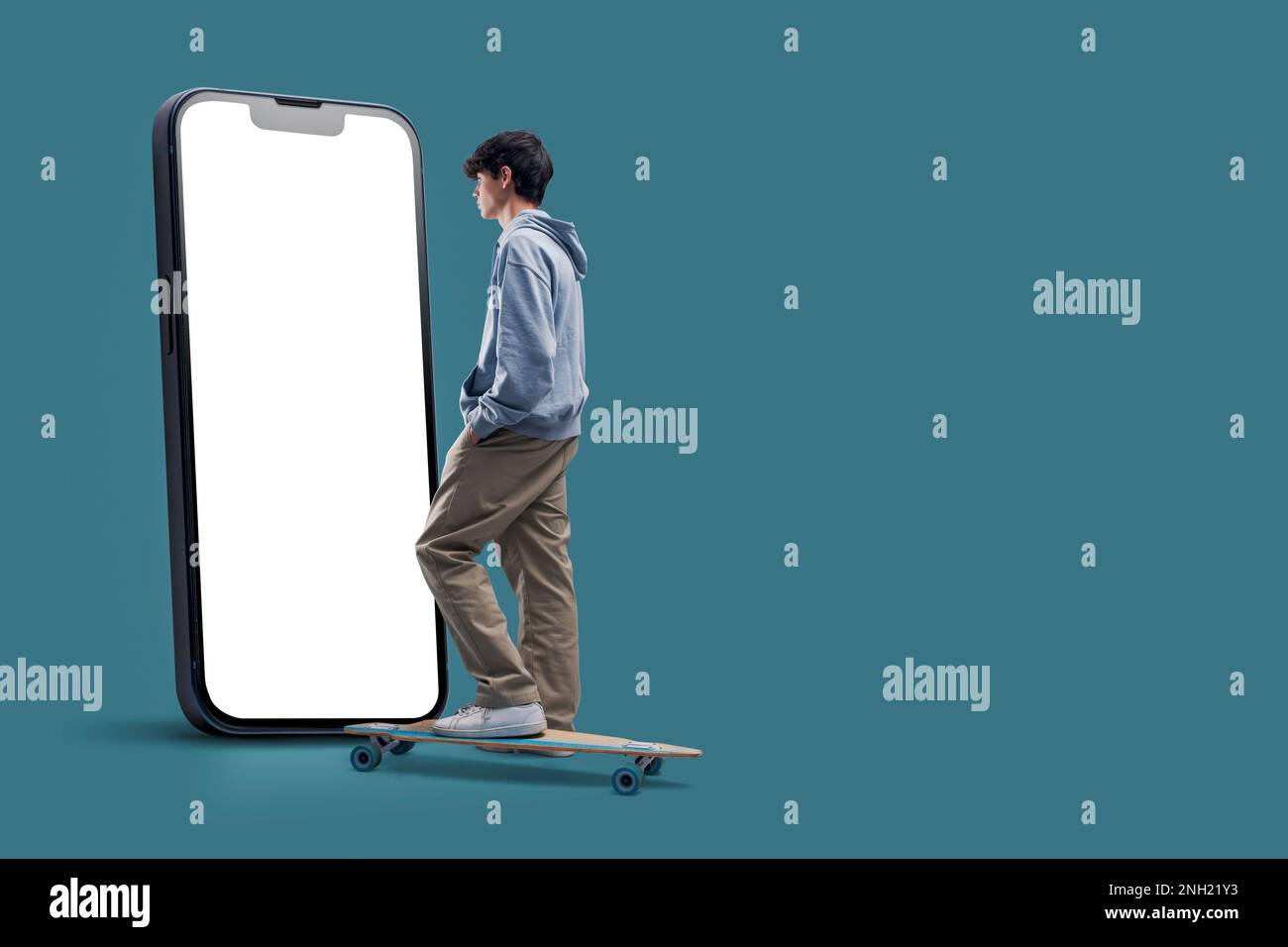 Cool adolescent skater staring at a big smartphone with blank screen ...