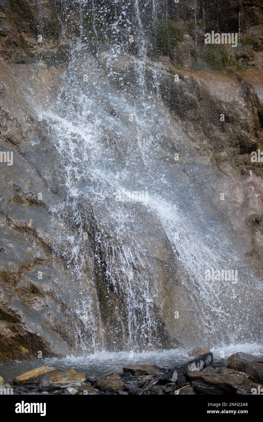 Beautiful waterfall in the mountains. Water flows down from the ...