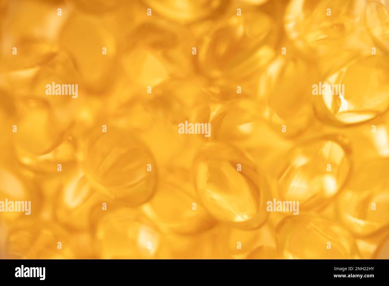 Blurred background with fish oil capsules. Yellow abstract pharma ...