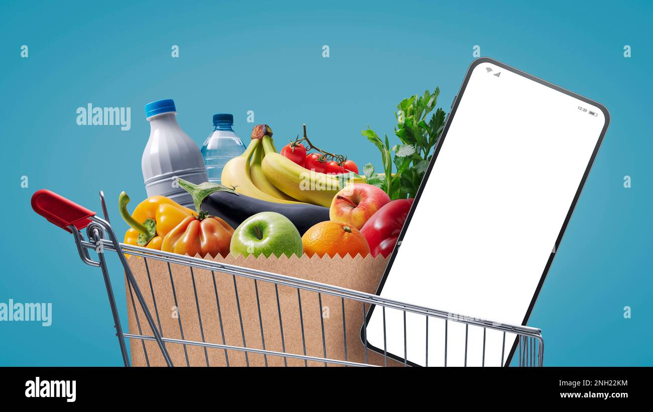 Supermarket shopping cart full of groceries and smartphone with blank ...