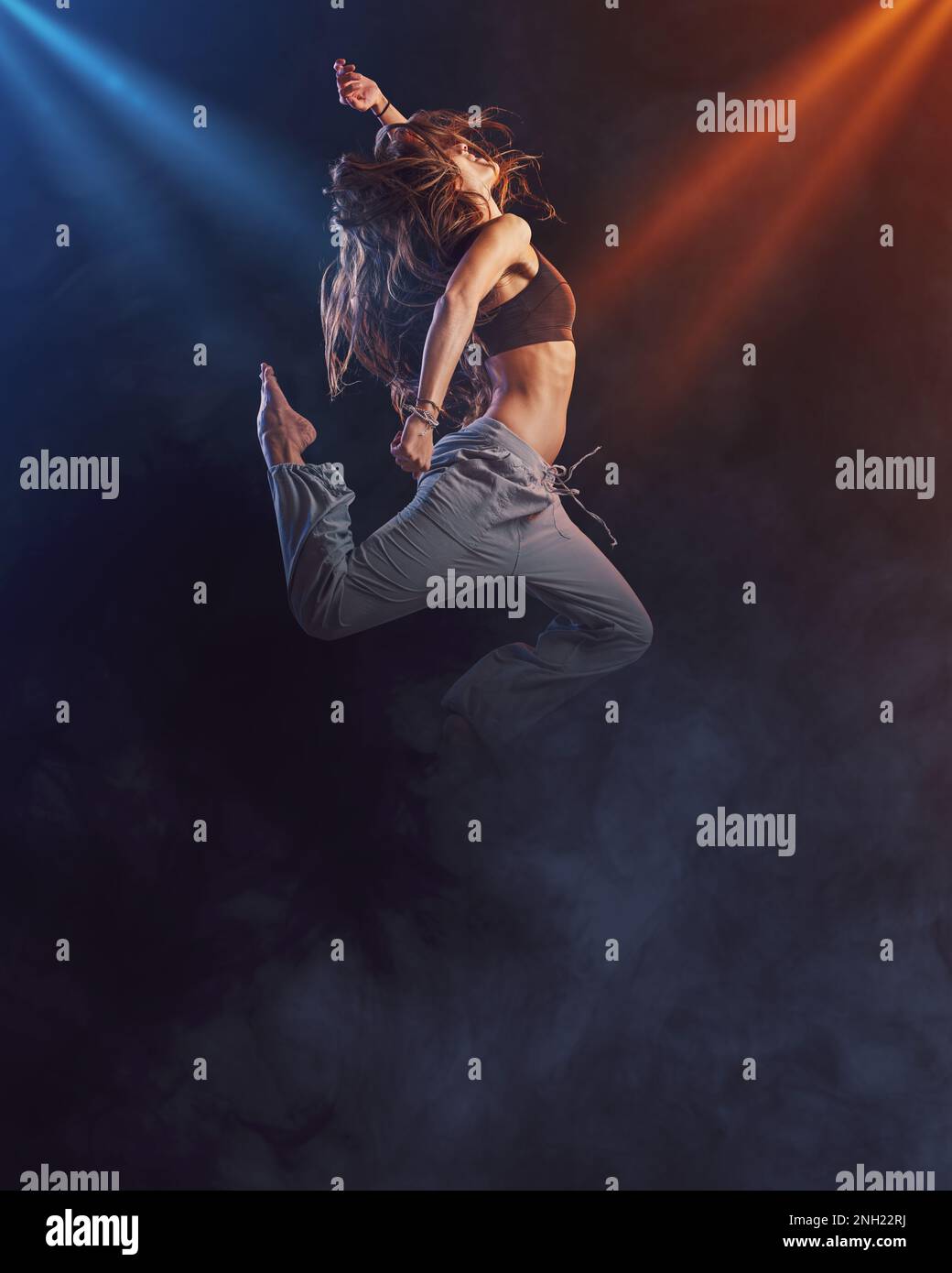 Professional female dancer performing on stage, she is jumping ...