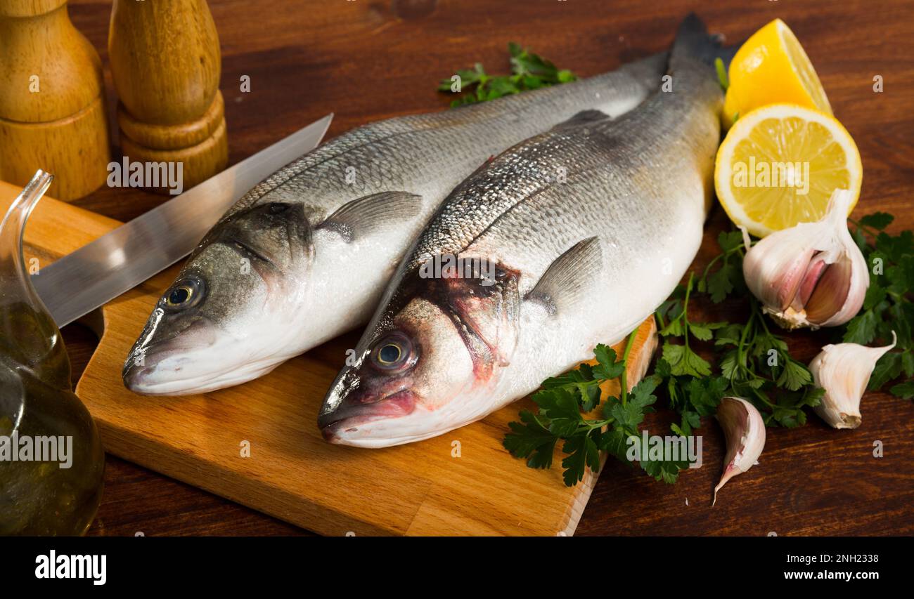Two raw sea bass fish Stock Photo - Alamy