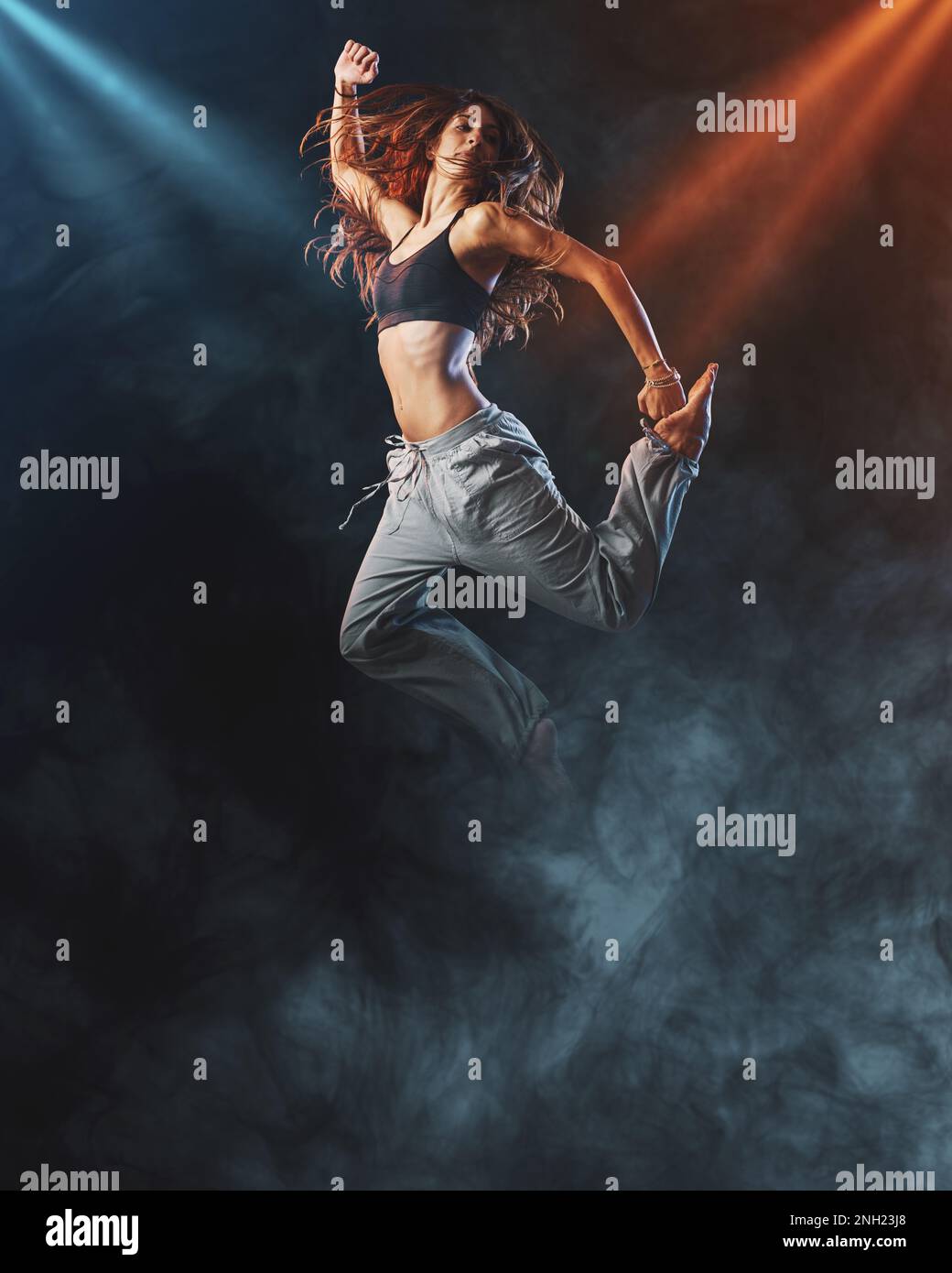 Professional female dancer performing on stage, she is jumping ...
