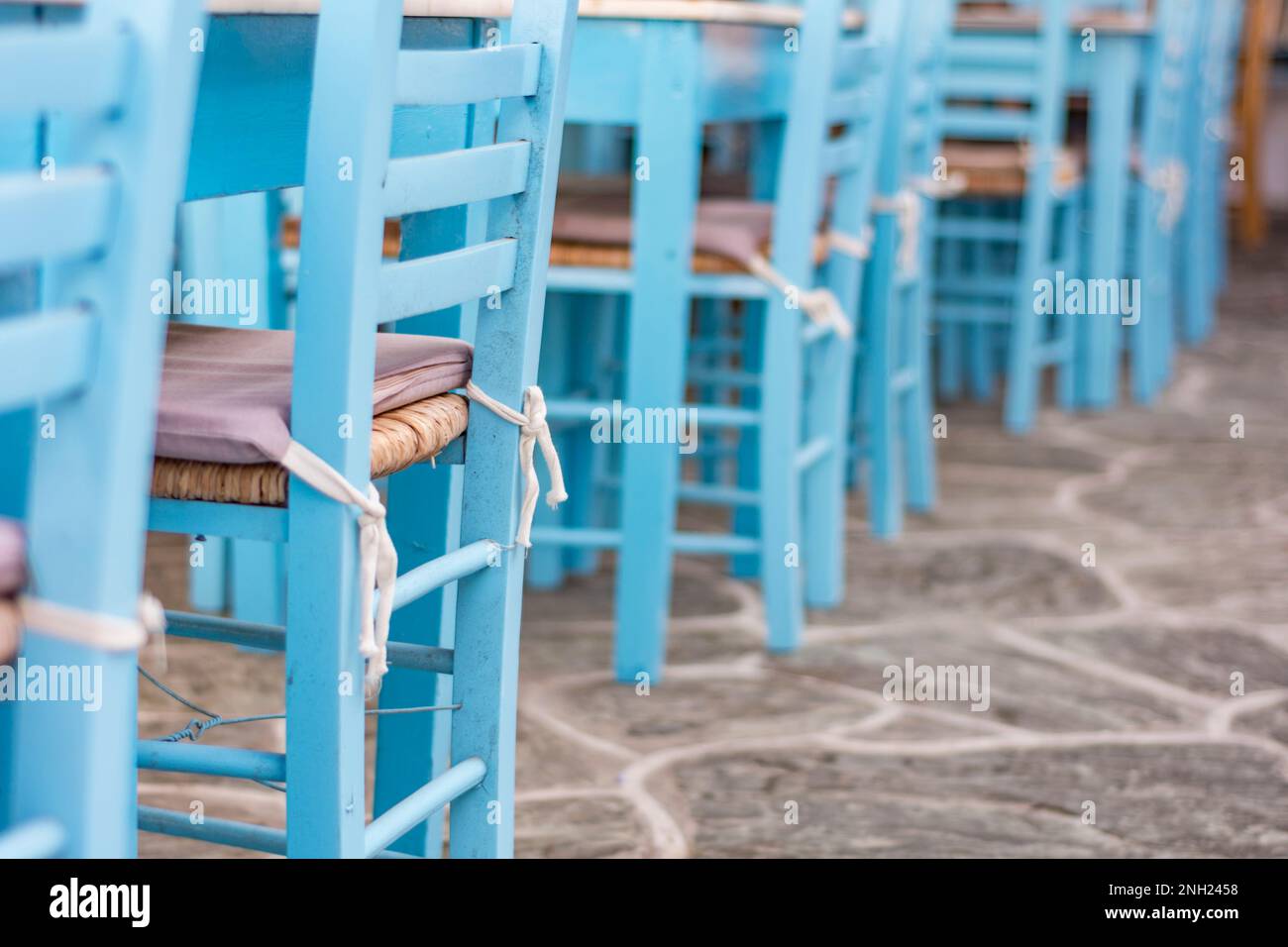 Row of chairs painted blue in a traditional Greek taverna in Chora ...