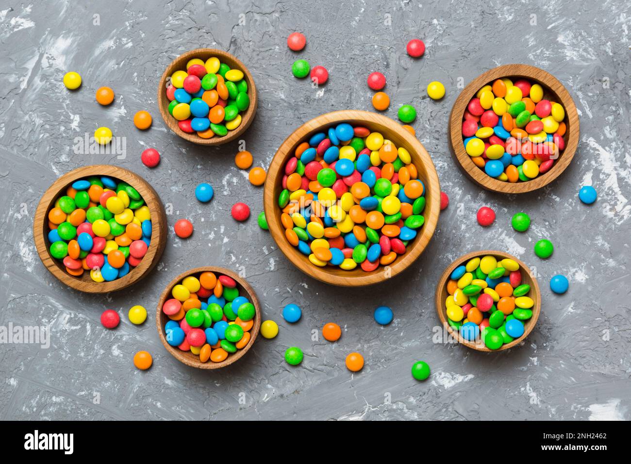 different colored round candy in bowl and jars. Top view of large ...