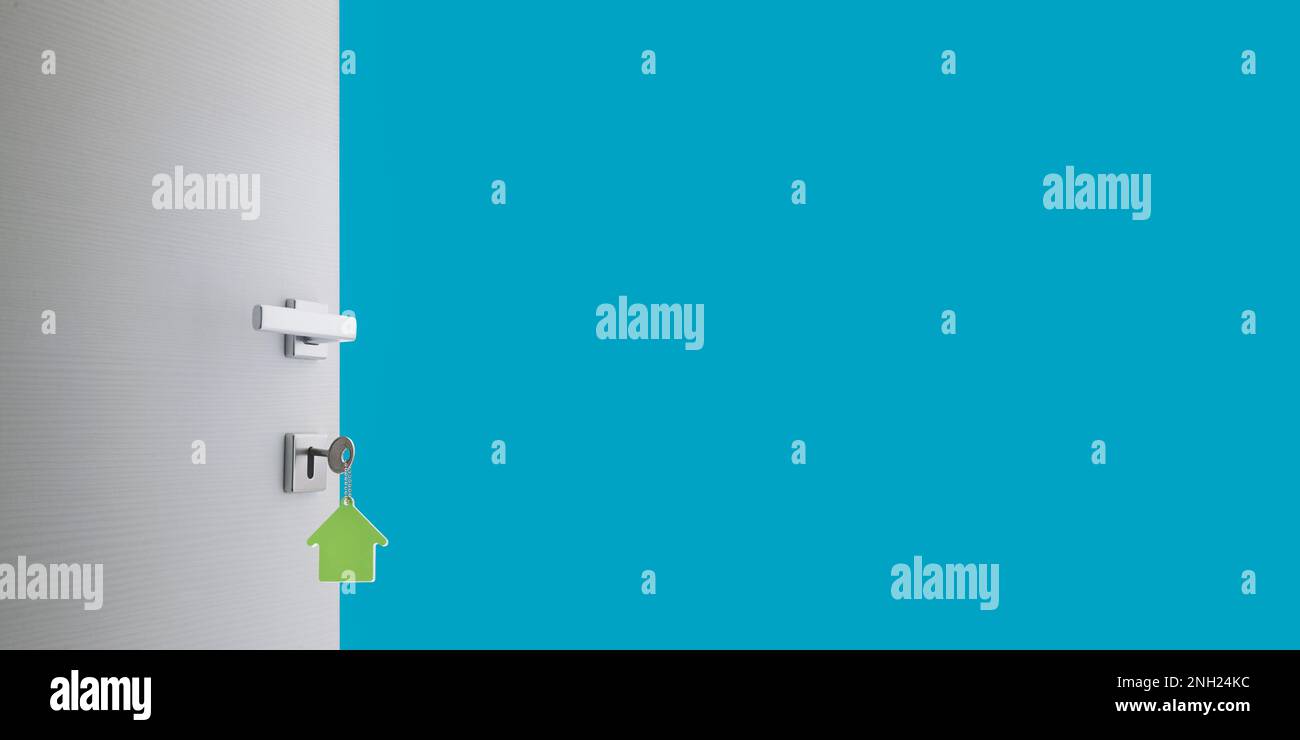 Welcome in your new home: open door with house key and copy space, real ...