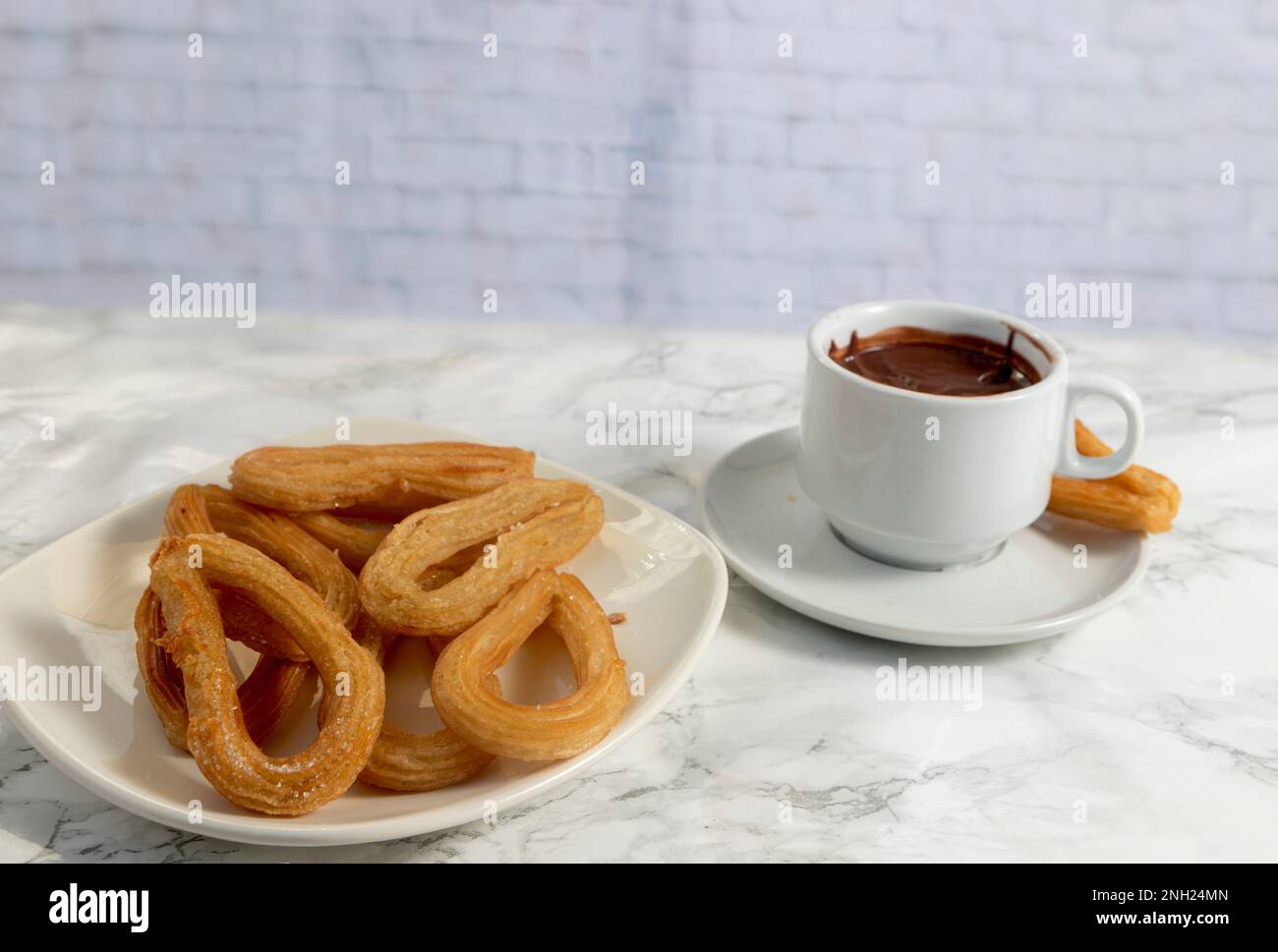 Plate of churros with sugar and cup of hot chocolate on marble ...