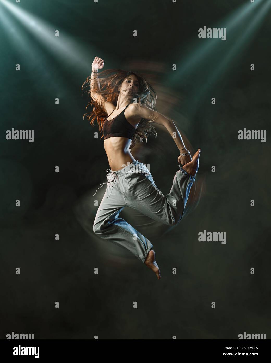 Professional female dancer performing on stage, she is jumping ...