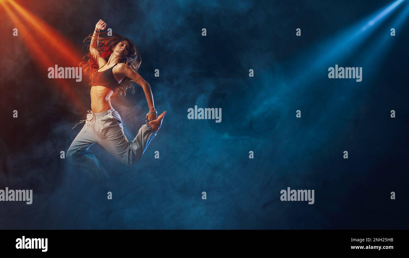 Professional female dancer performing on stage, she is jumping ...