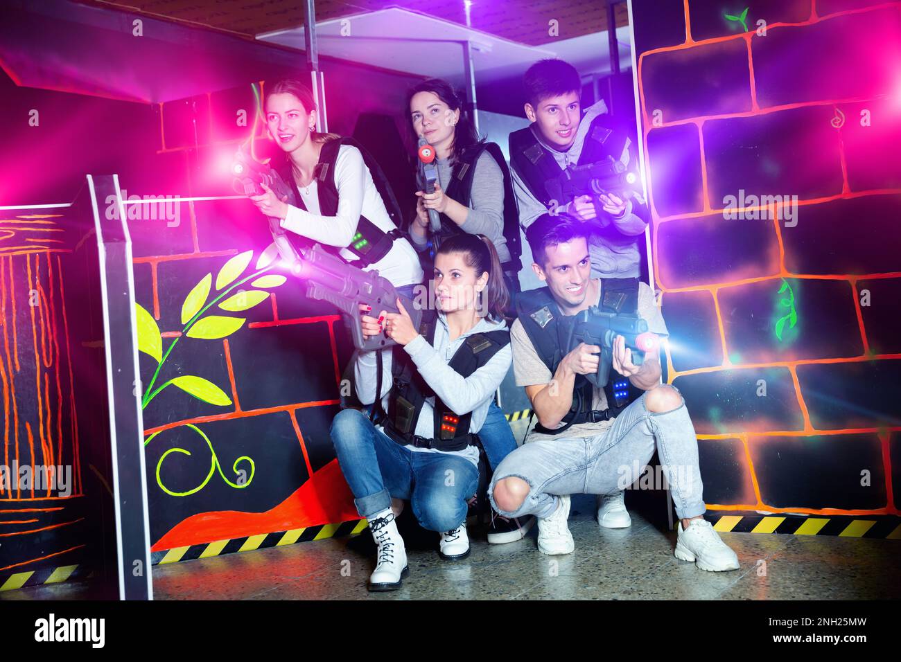 Group glad people playing laser tag game Stock Photo - Alamy