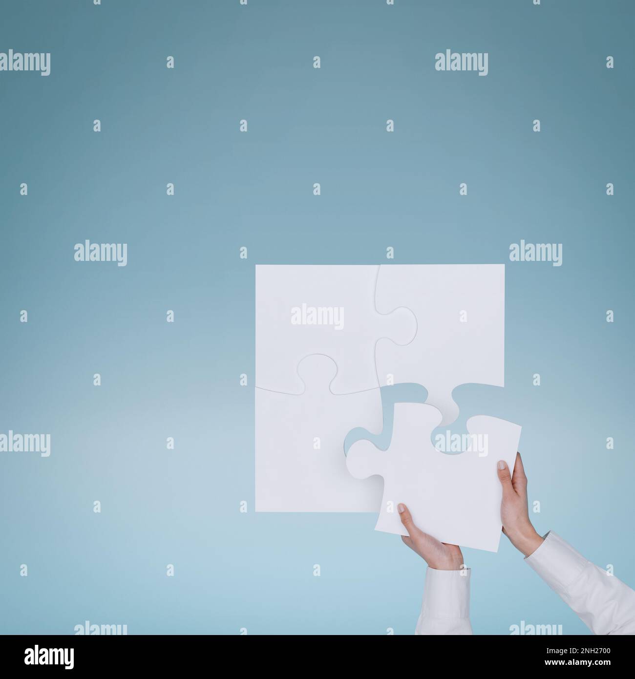 Corporate business person solving a jigsaw puzzle and adding the last ...