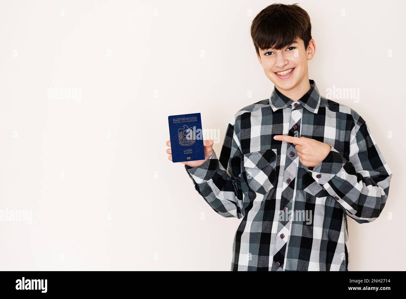 Young teenager boy holding United Arab Emirates passport looking ...