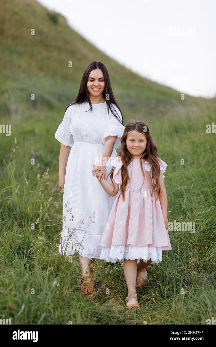 Mothers Day, Women's day. Happy young beautiful mother is hugging her little daughter in the ...