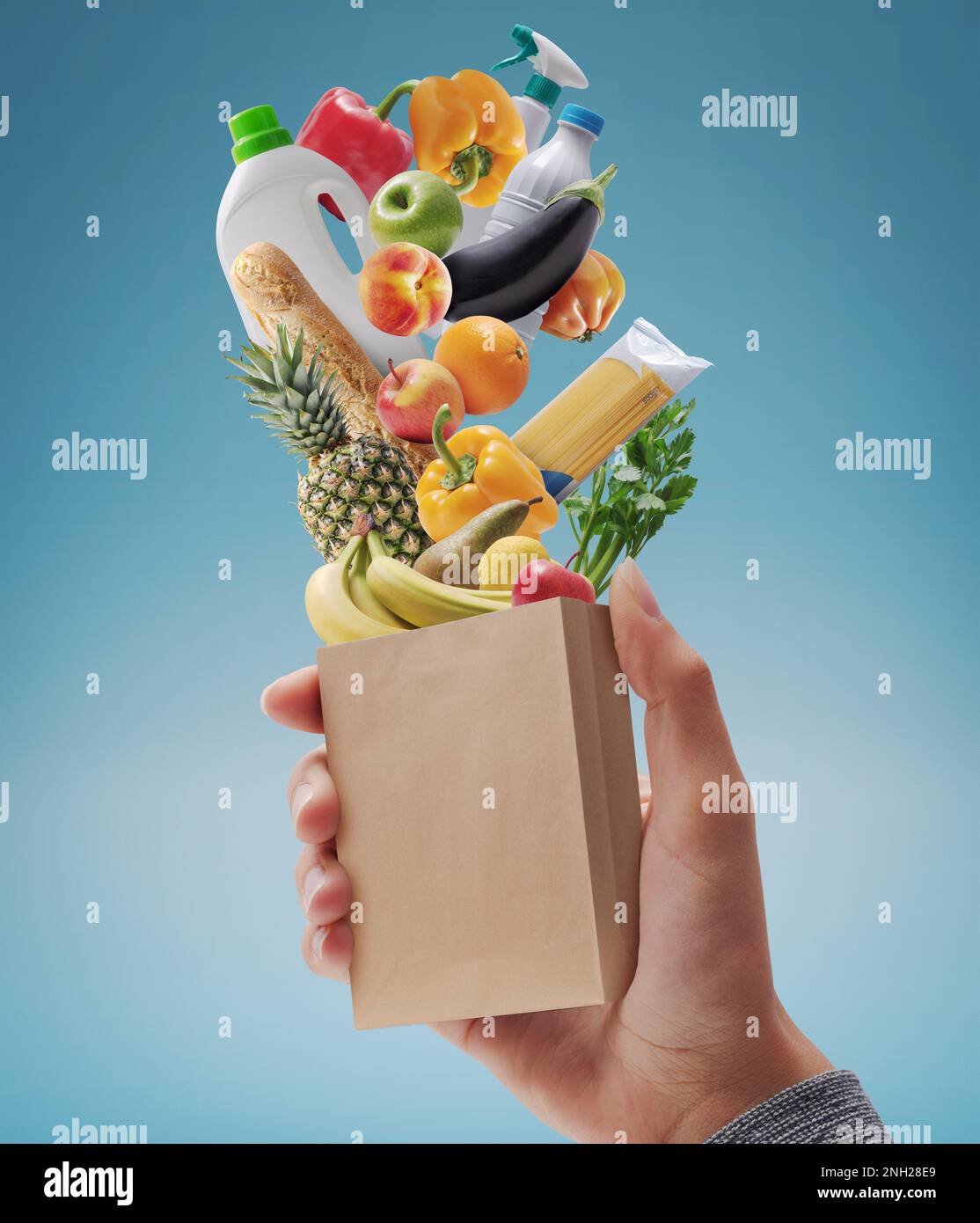 Customer holding a miniature paper bag with fresh groceries falling ...