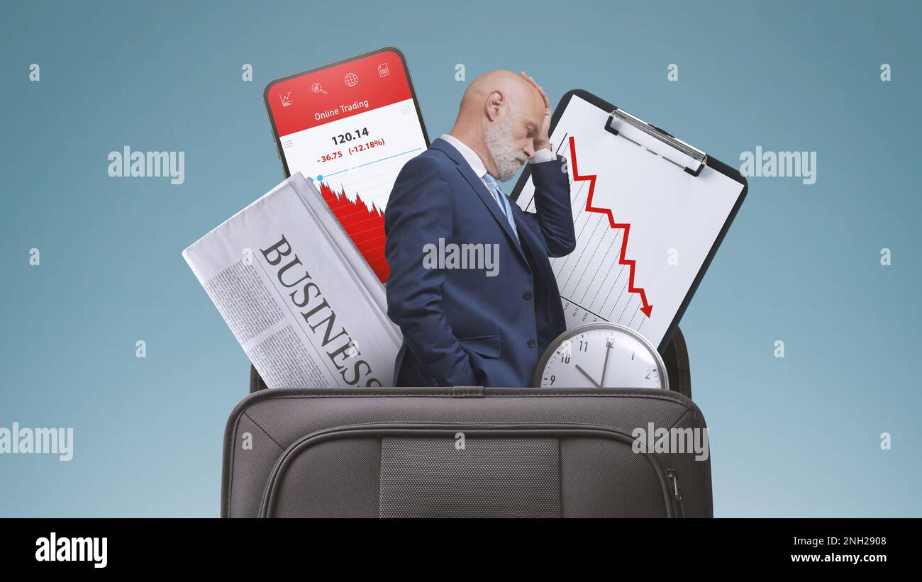 Stressed sad businessman and financial graphs showing loss in a ...